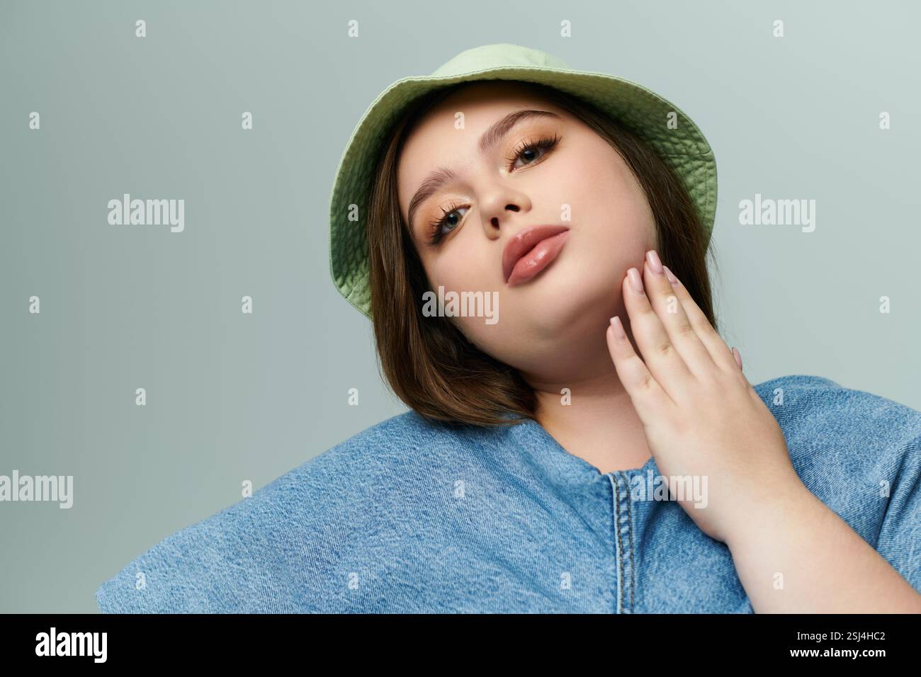 A young, confident plus size woman elegantly poses, highlighting her ...