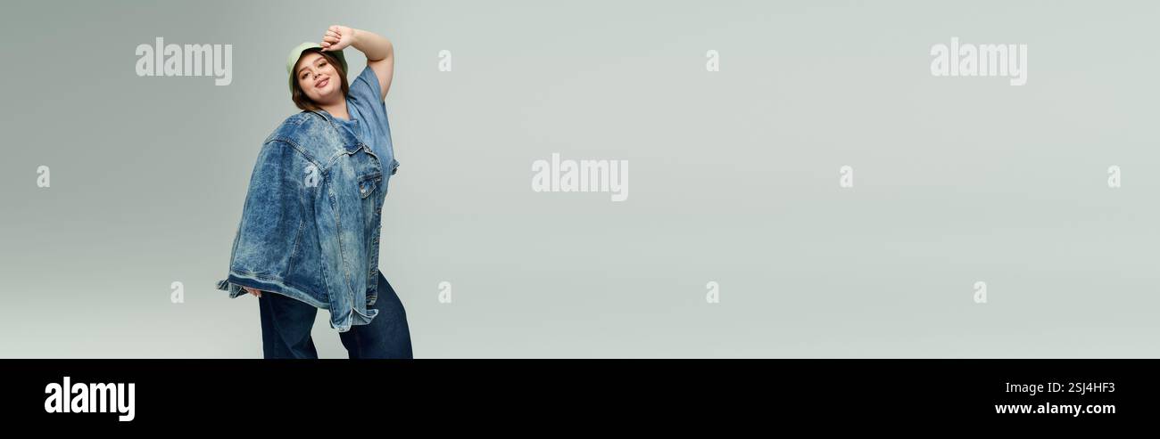 A young plus size woman happily poses in a denim jacket, reflecting her ...