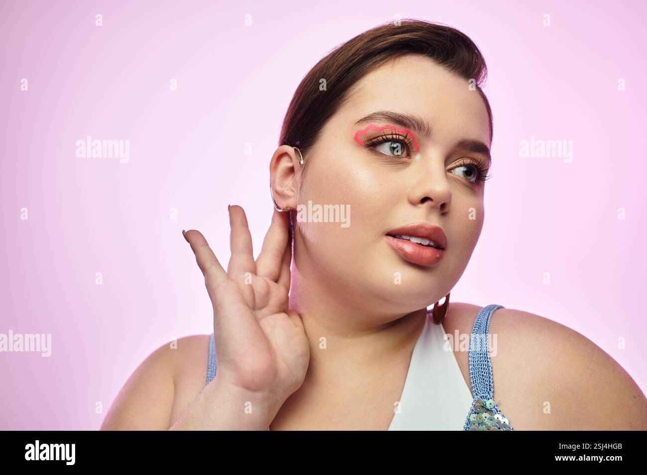 A young and pretty plus size woman playfully poses with a charming ...