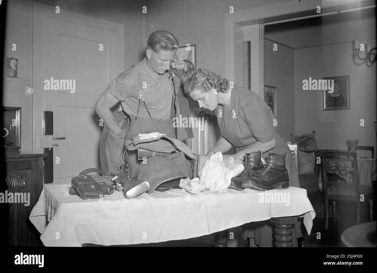 Mobilmachungs-Reportage 1947: Der Einberufene packt mit der Mutter/Frau ...