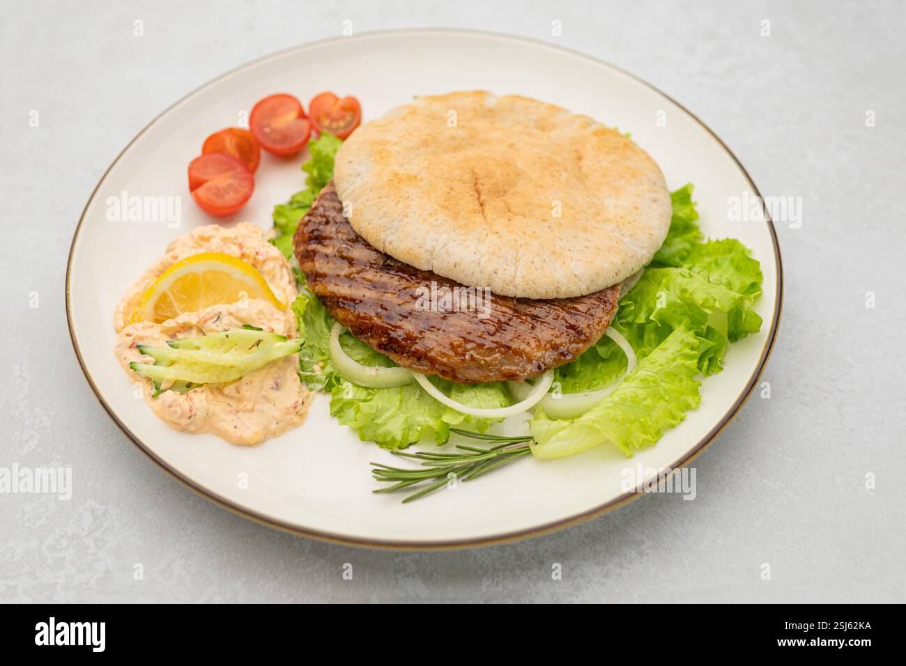 Serbian pljeskavica served with traditional Balkan side dishes. Balkan ...