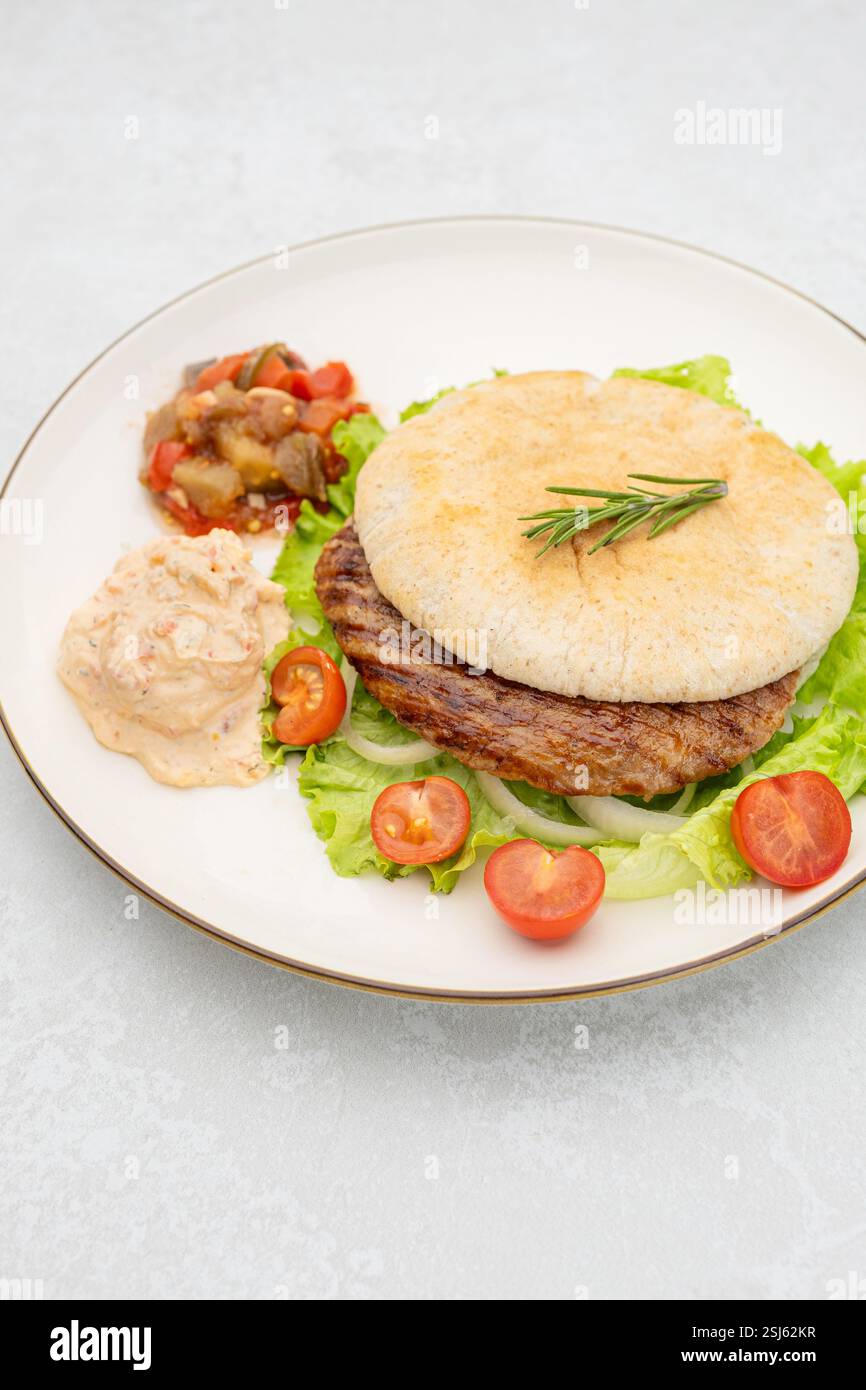 Serbian pljeskavica served with traditional Balkan side dishes. Balkan ...