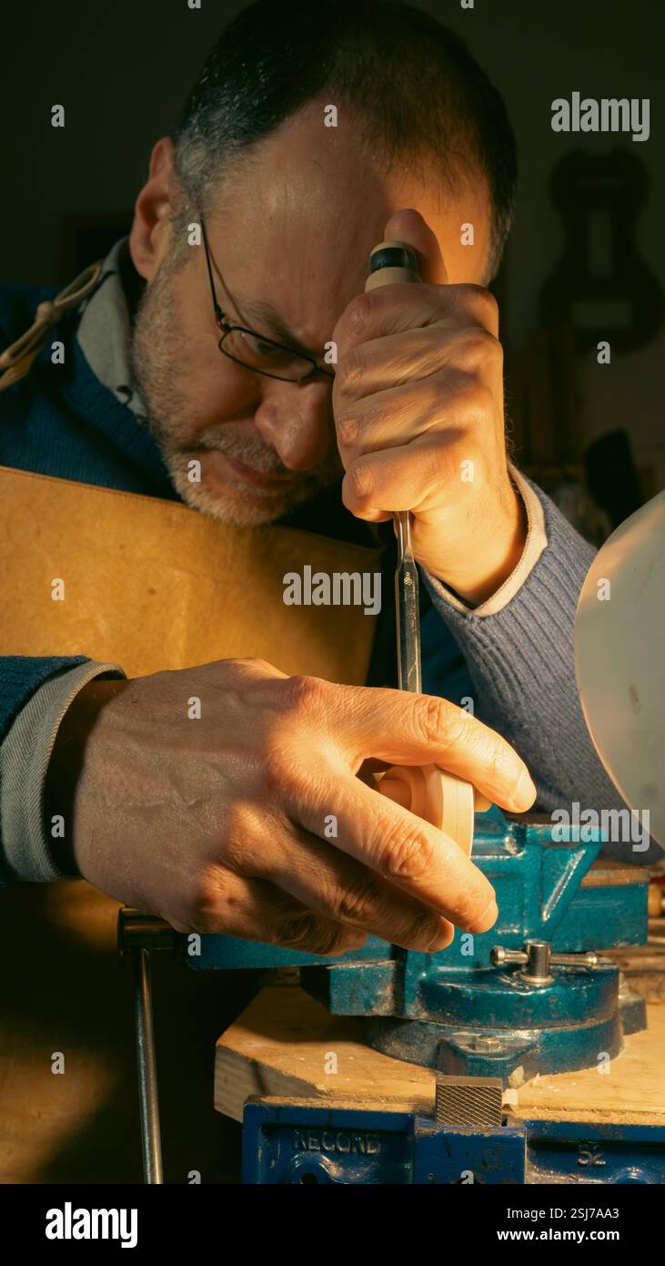 Cremona, Italy - February 6th 2025 Master Luca Tenore In a dimly lit ...