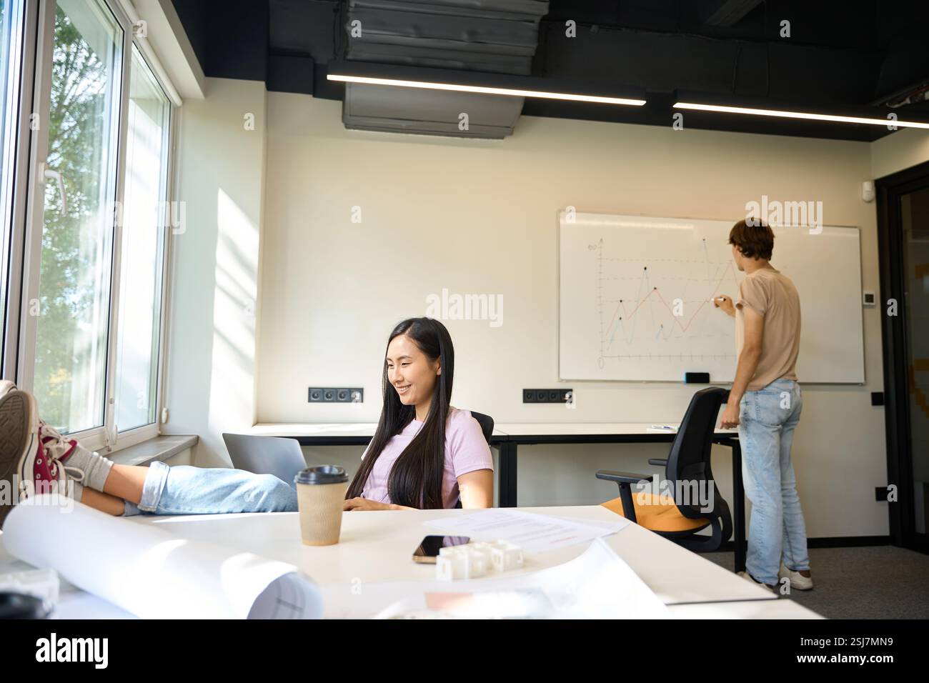 Creative guy drawing charts on whiteboard Stock Photo - Alamy