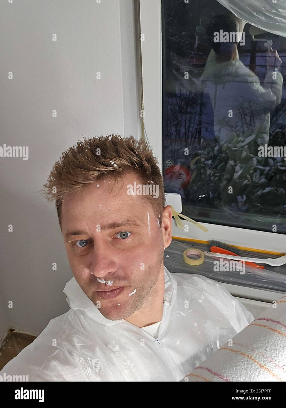 A young man showcases his playful nature with bright, colorful paint ...