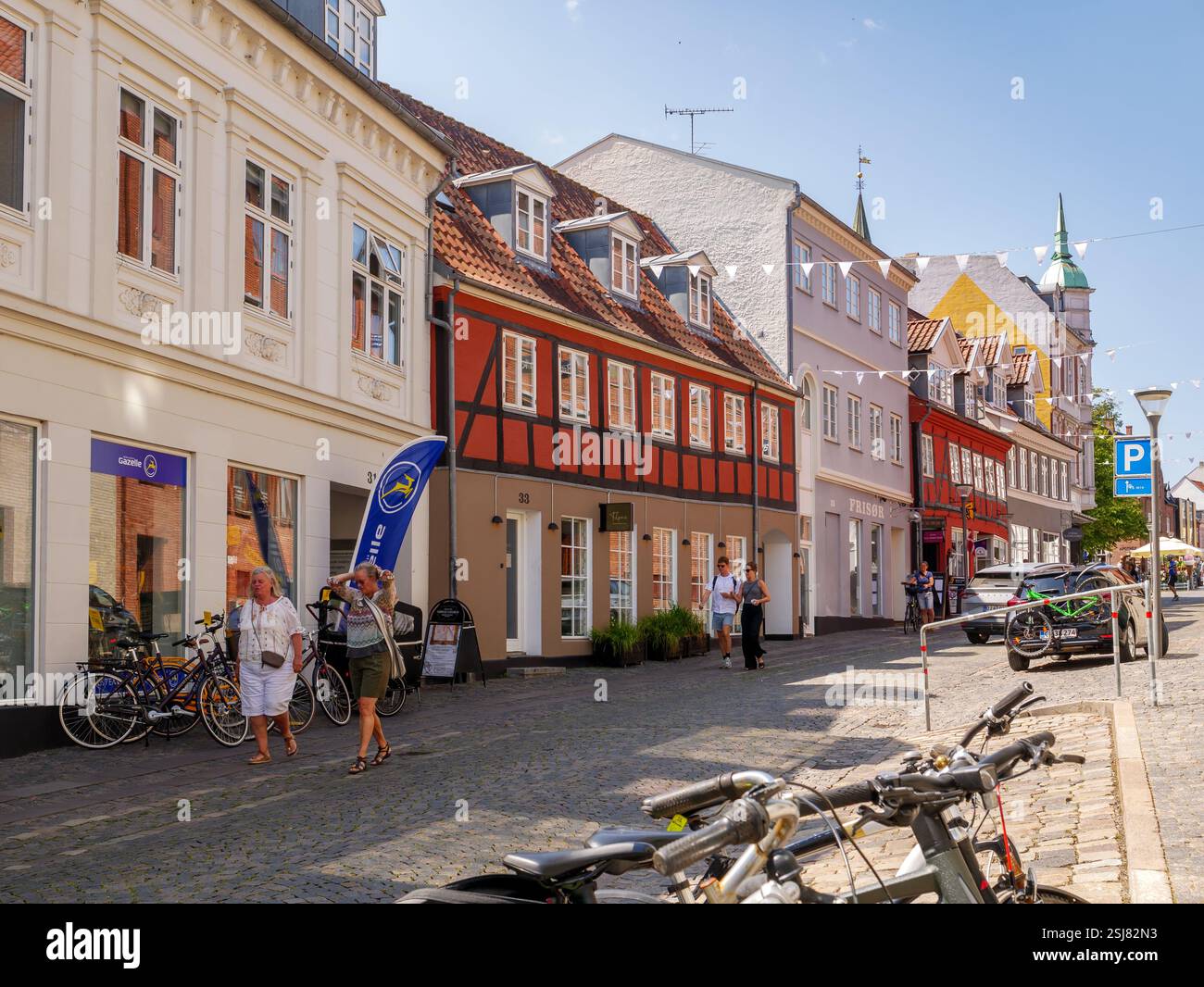 Street scene on Brogade with shops, bicycles and people in old town of ...