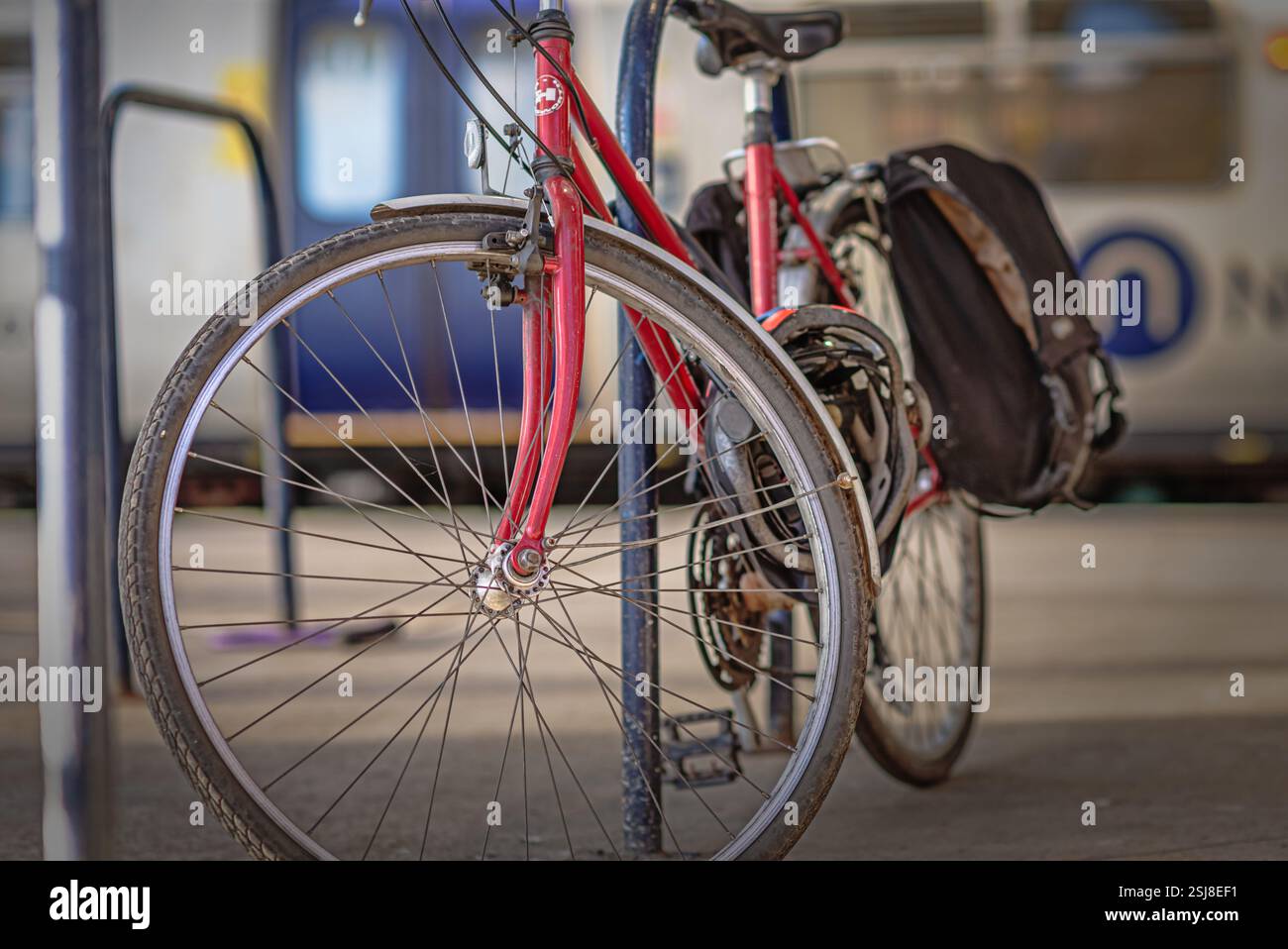 A bicycle is is standing on a railway platform fastened to a rack. A ...