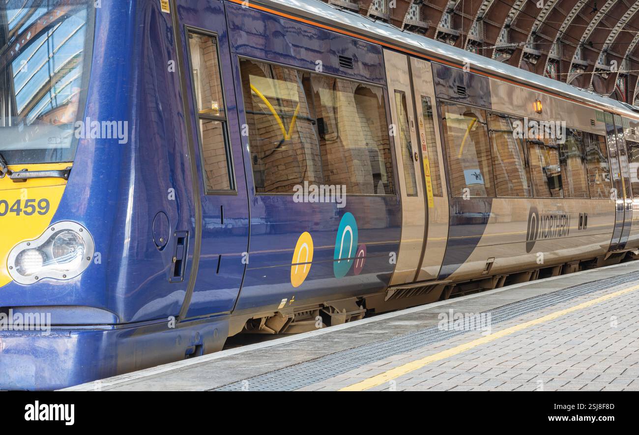 A train stands at a railway station platform covered by a historic ...