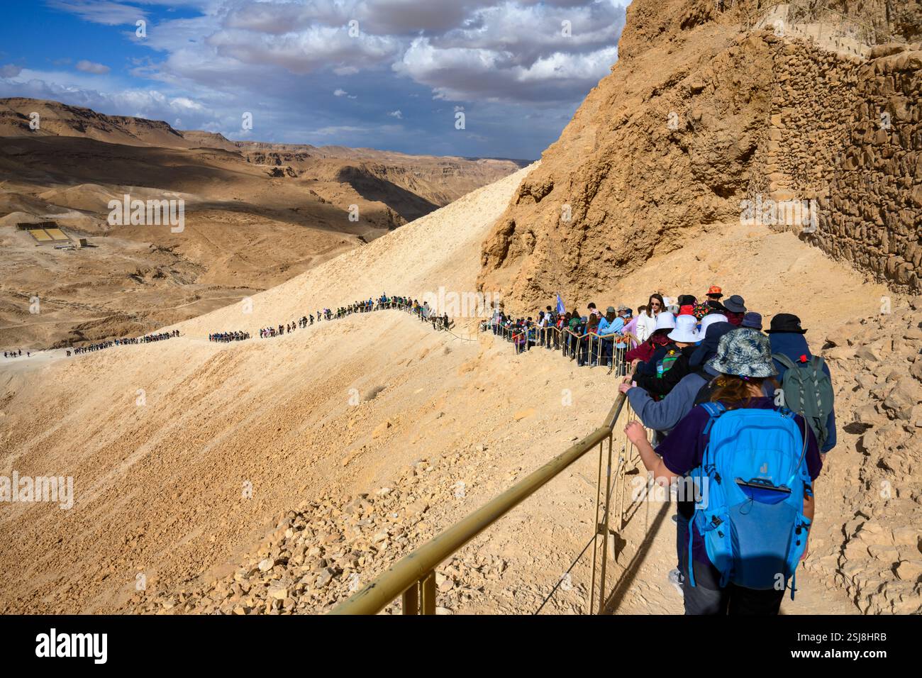 Large groups of visitors are hiking down the ramp path from the summit ...