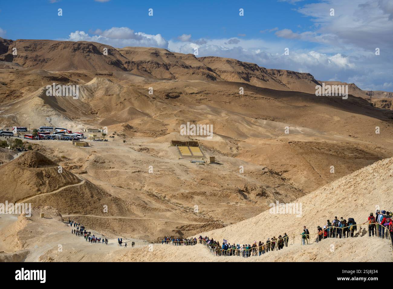 Large groups of visitors are hiking down the ramp path from the summit ...
