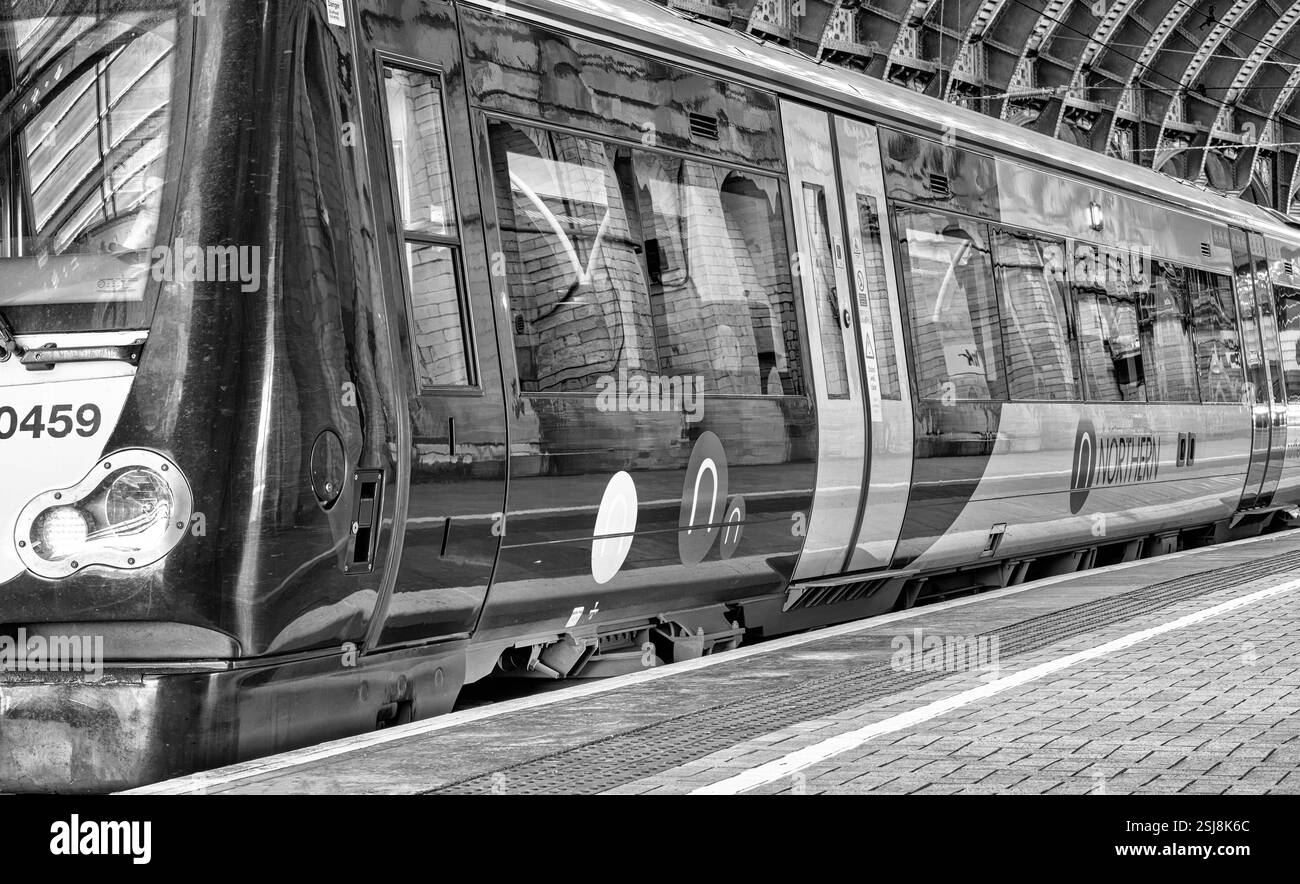 A train stands at a railway station platform covered by a historic ...