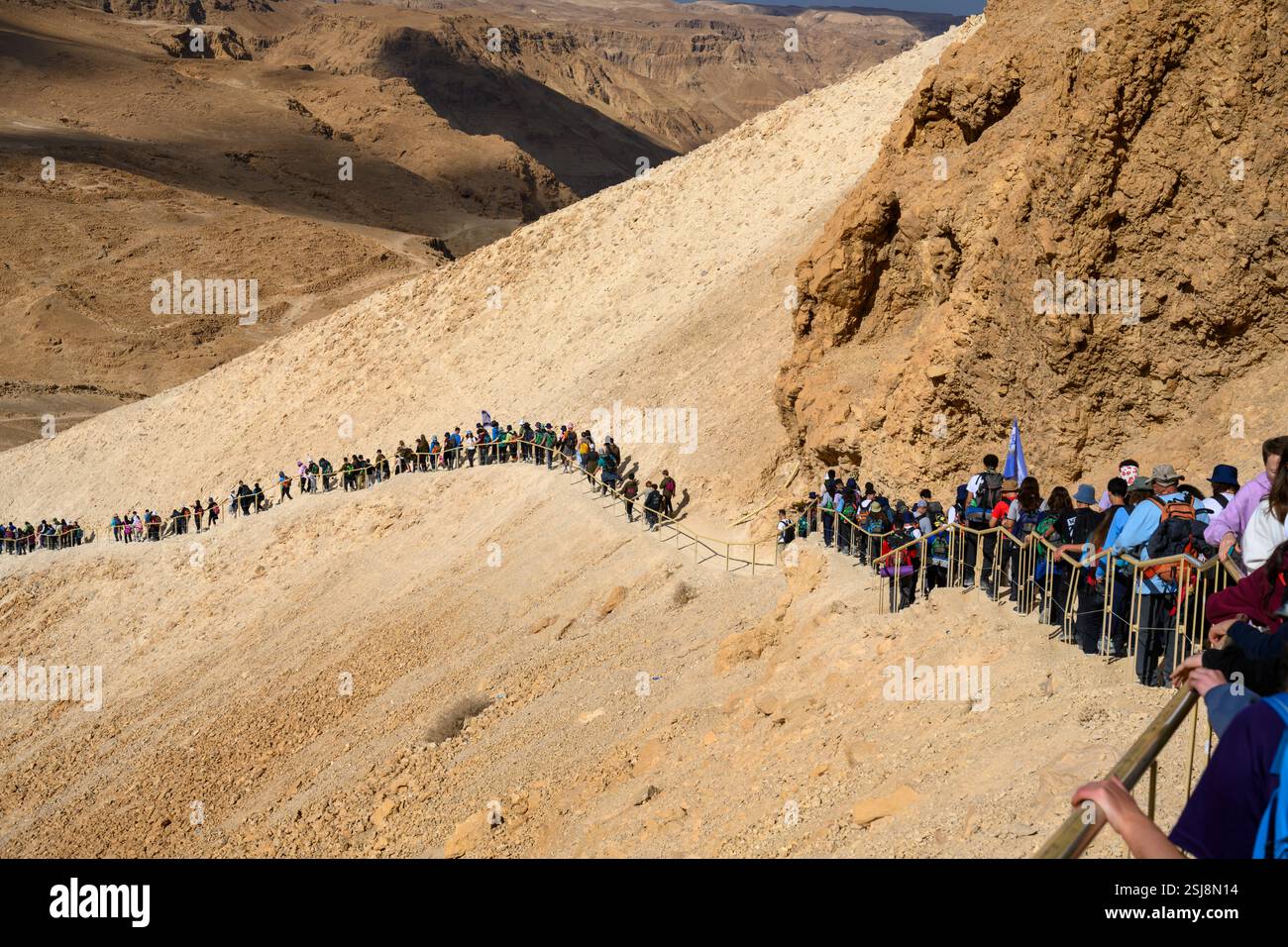 Large groups of visitors are hiking down the ramp path from the summit ...