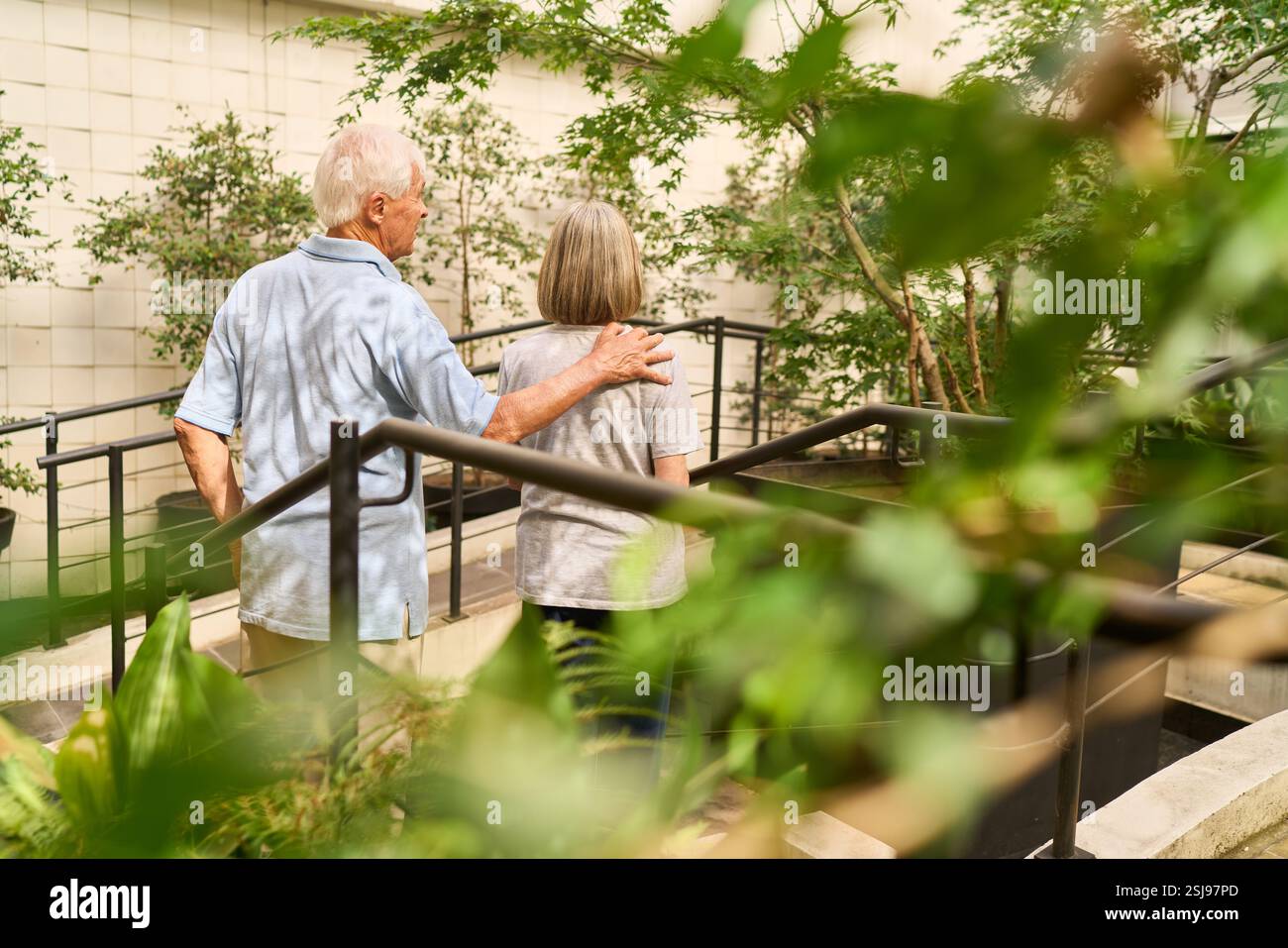 Elderly individuals enjoying a peaceful walk in a garden within a ...