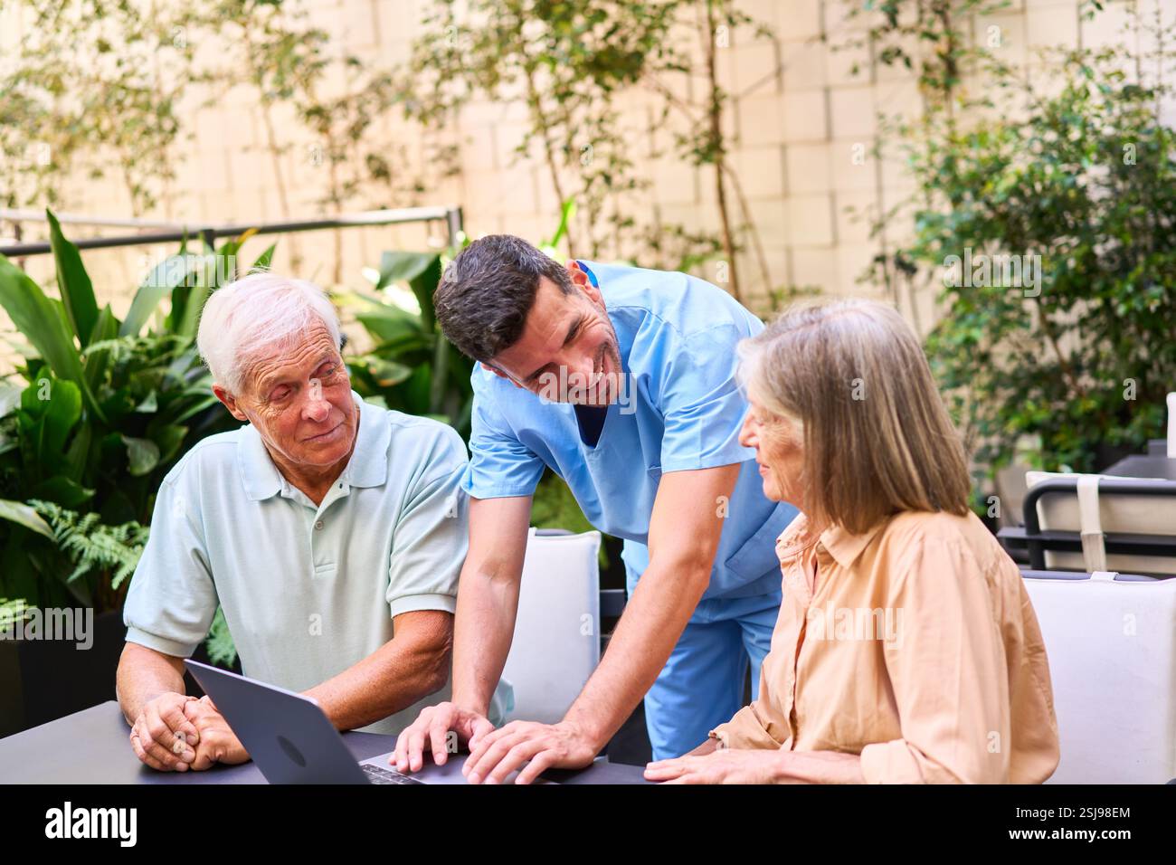 A healthcare worker interacts with senior patients outdoors ...