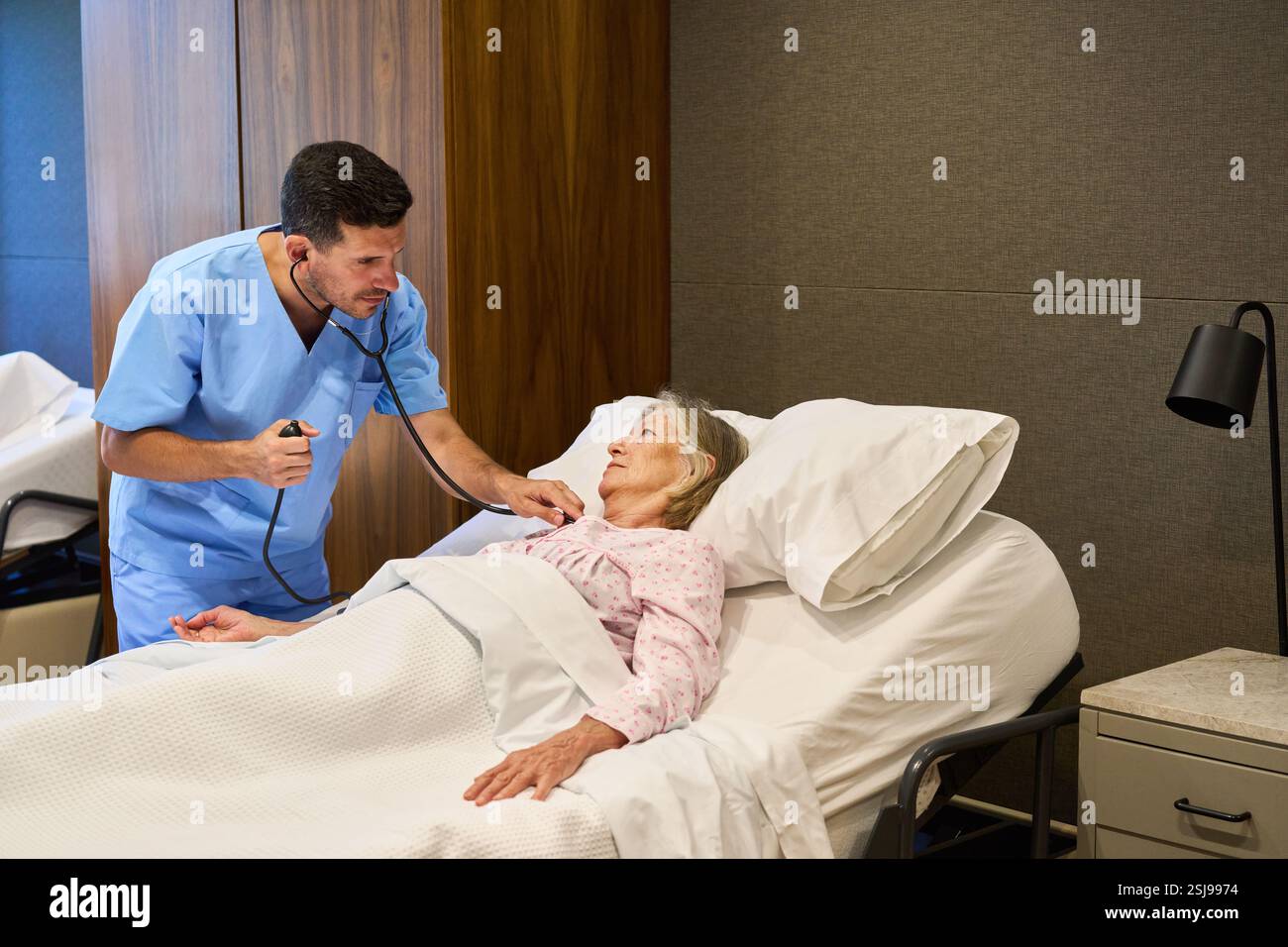 A medical professional attentively examines an elderly patient in a ...