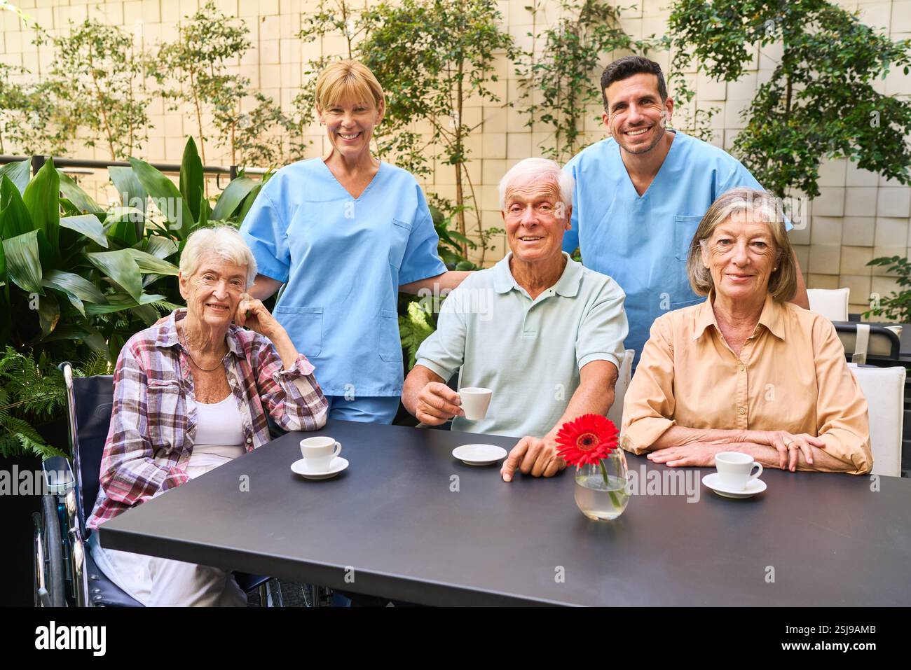 Friendly caregivers and elderly residents spending quality time in a ...