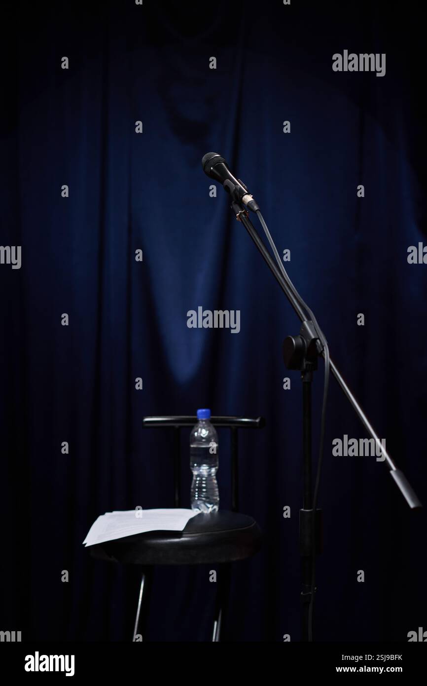 Standing microphone with stand on stage with blue curtains in ...