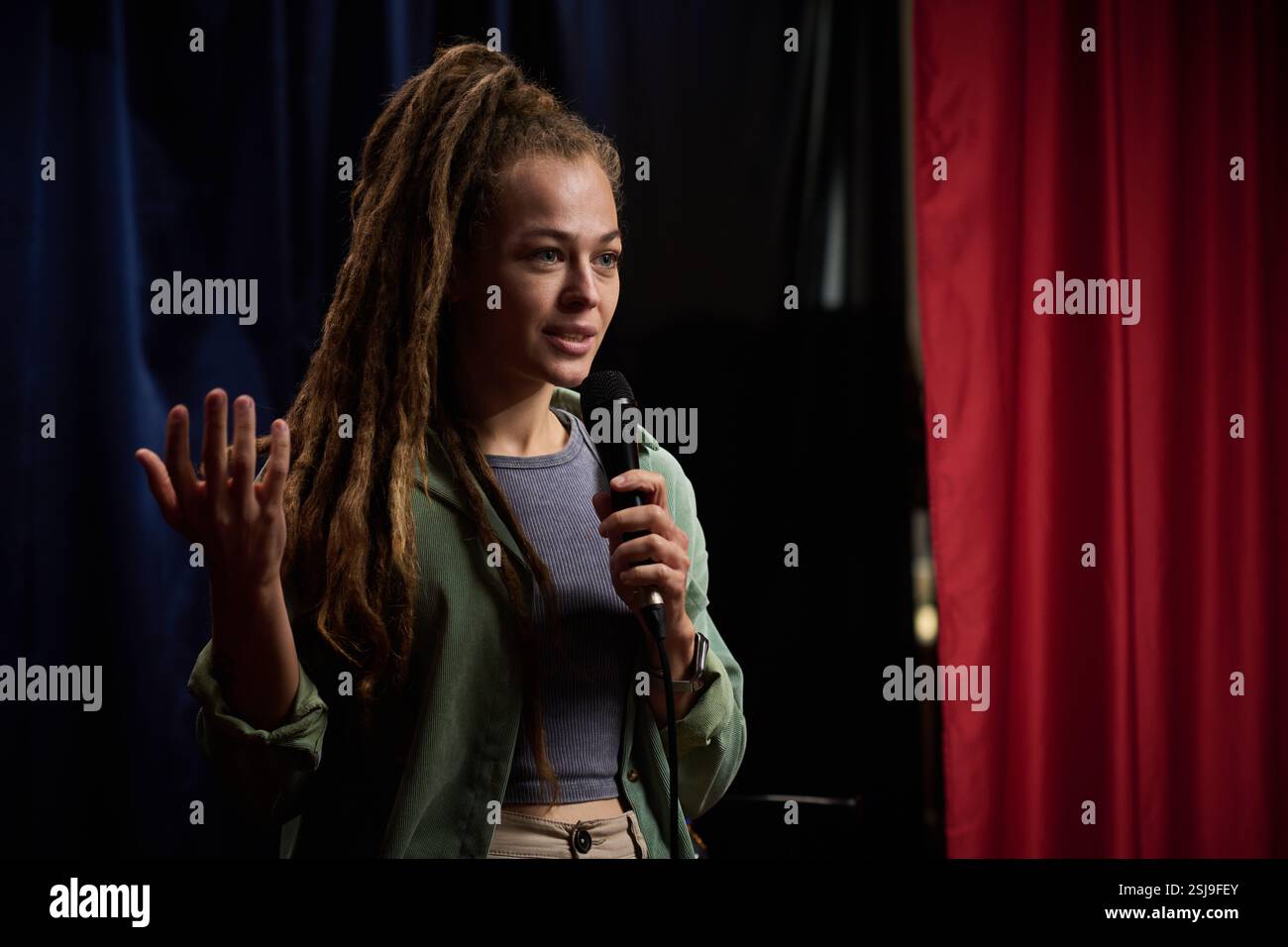 African American woman in green blouse delivering comedy routine on ...