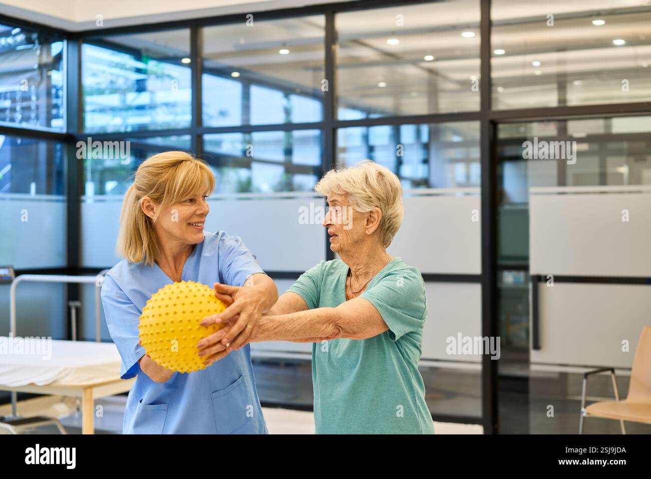 Rehabilitation session showing a therapist helping an elderly woman ...