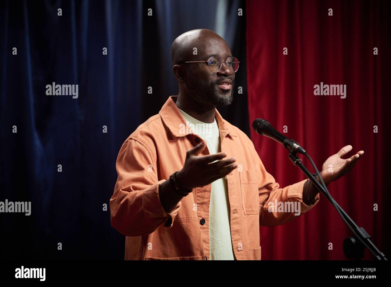 Black person gesturing with hands while speaking into microphone on ...