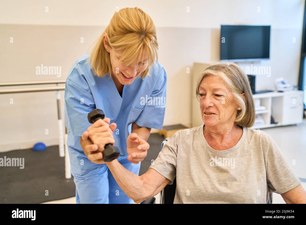 Senior woman performing rehabilitation exercises with assistance from a ...