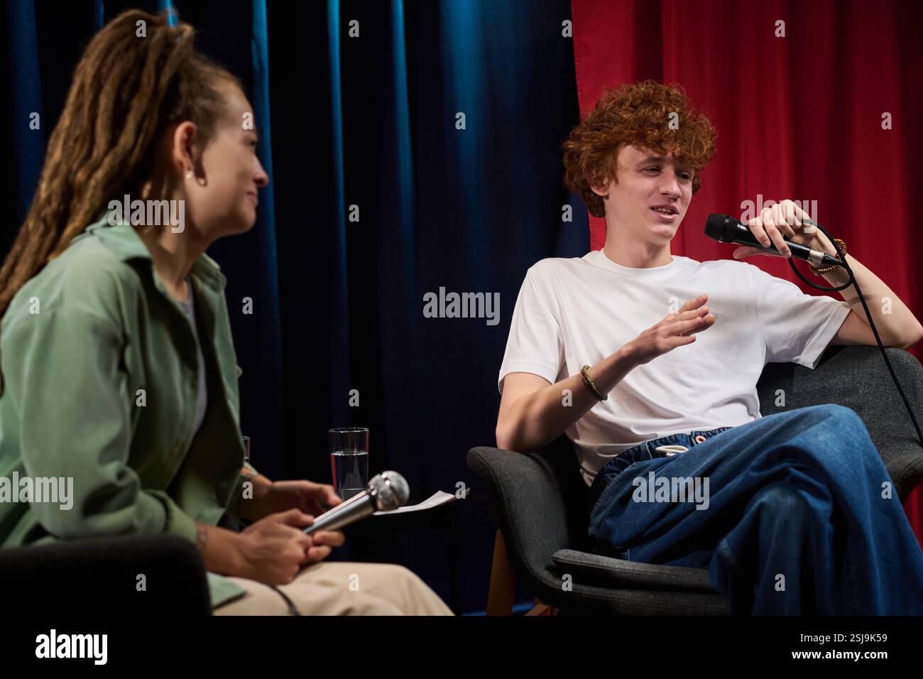 Two individuals sharing an intense interview session on stage with ...