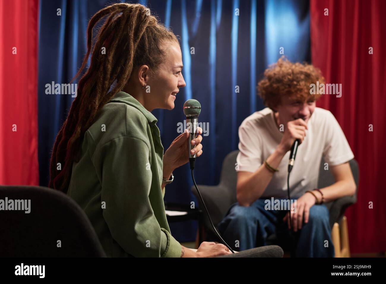 Two people engaging in an animated podcast conversation in recording ...