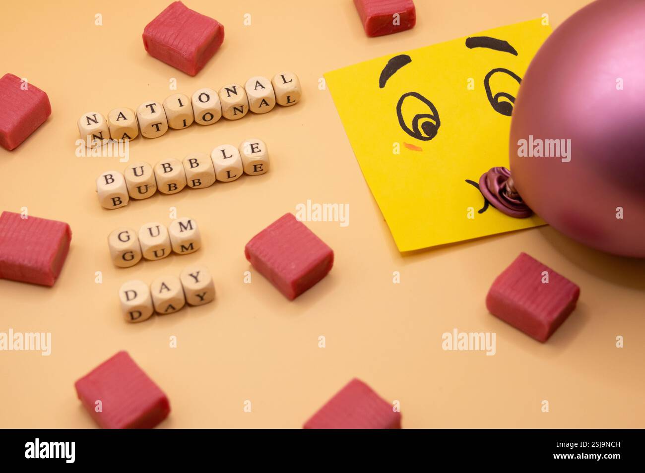 A concept of an emoticon notepad, blowing a bubble of bubble gum on a ...