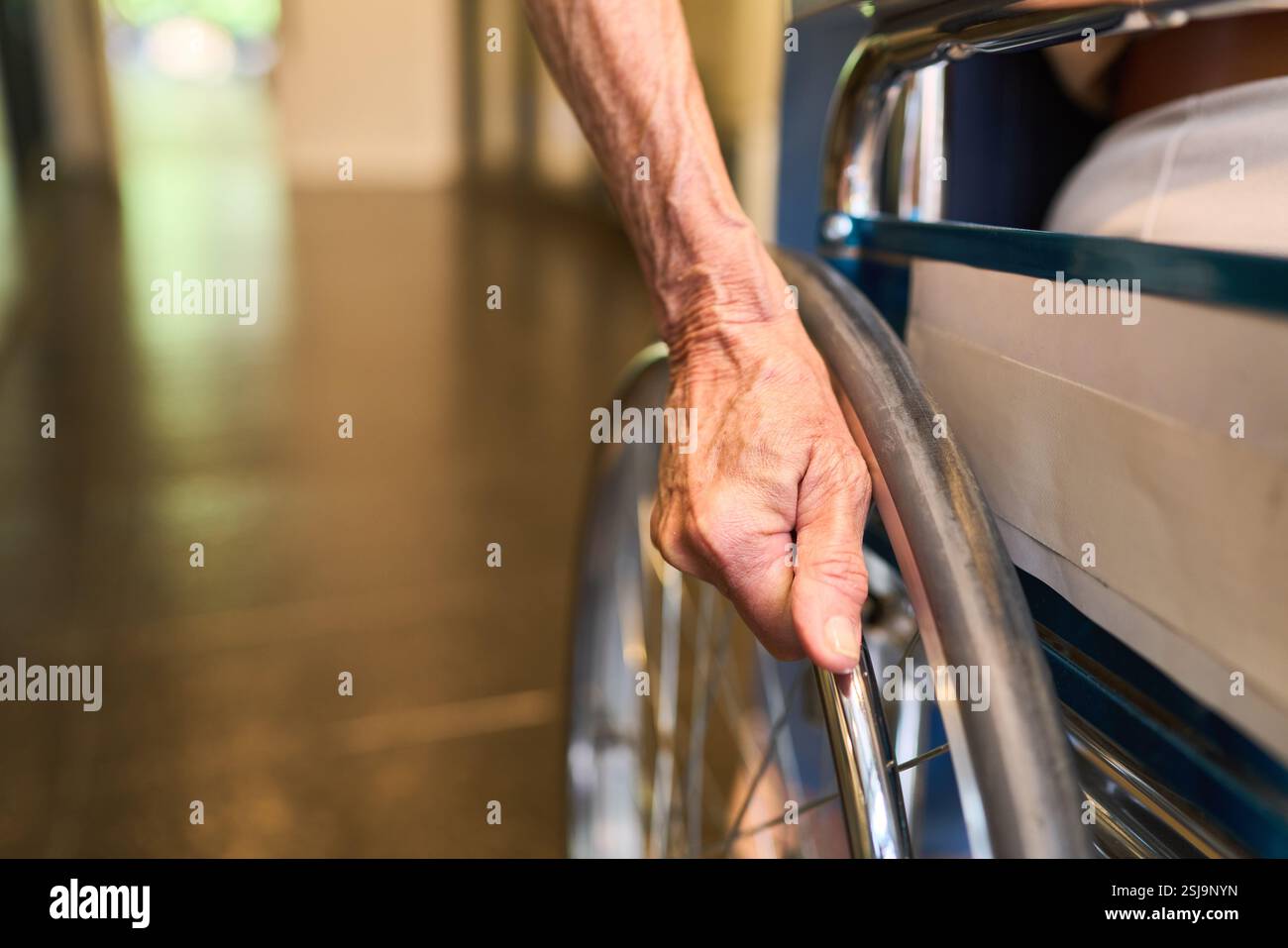A detailed photograph of an elderly person's hand gripping the wheel of ...