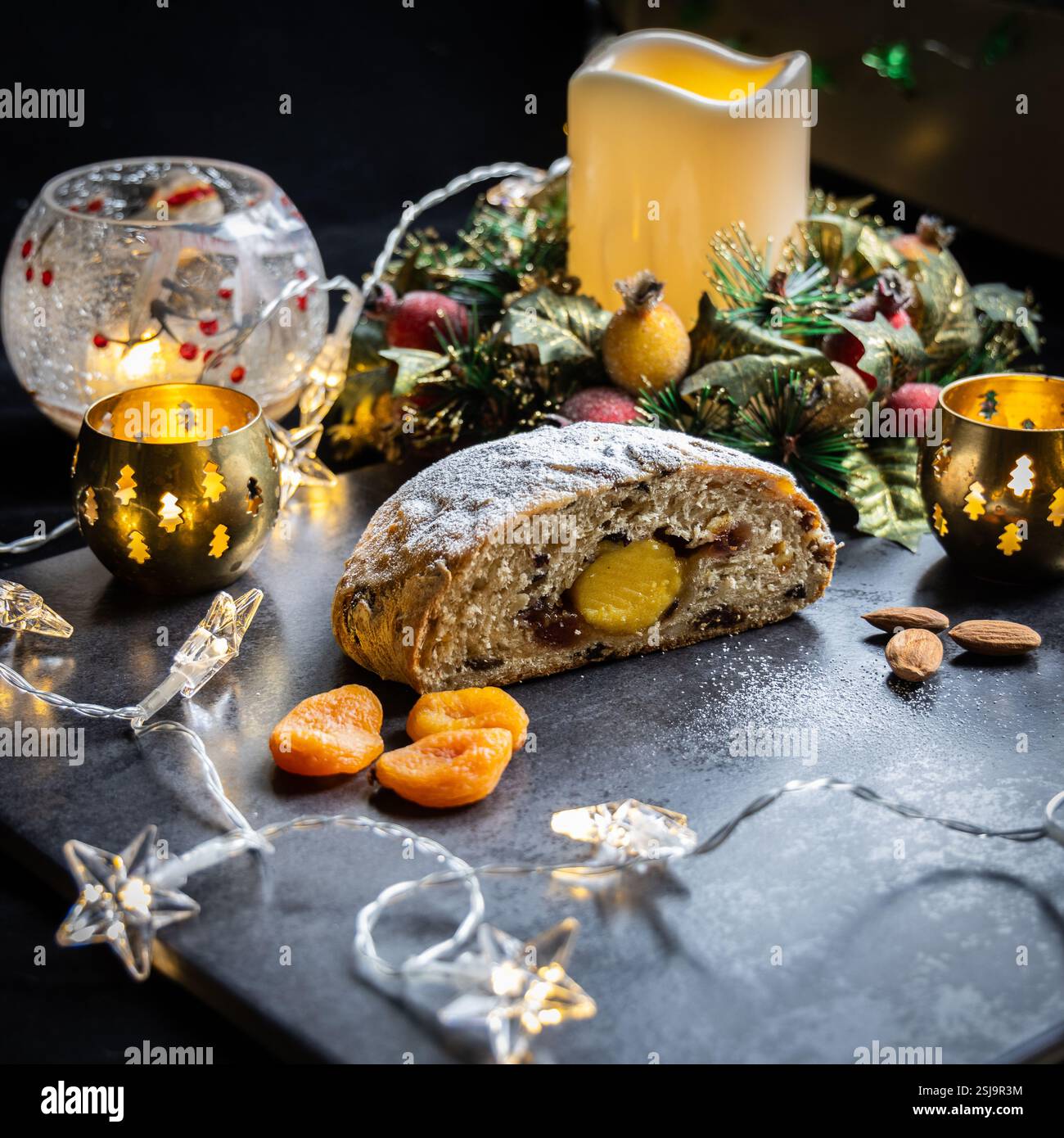 Christmas baking-Stollen loaf cut open showing marzipan on black tiled ...