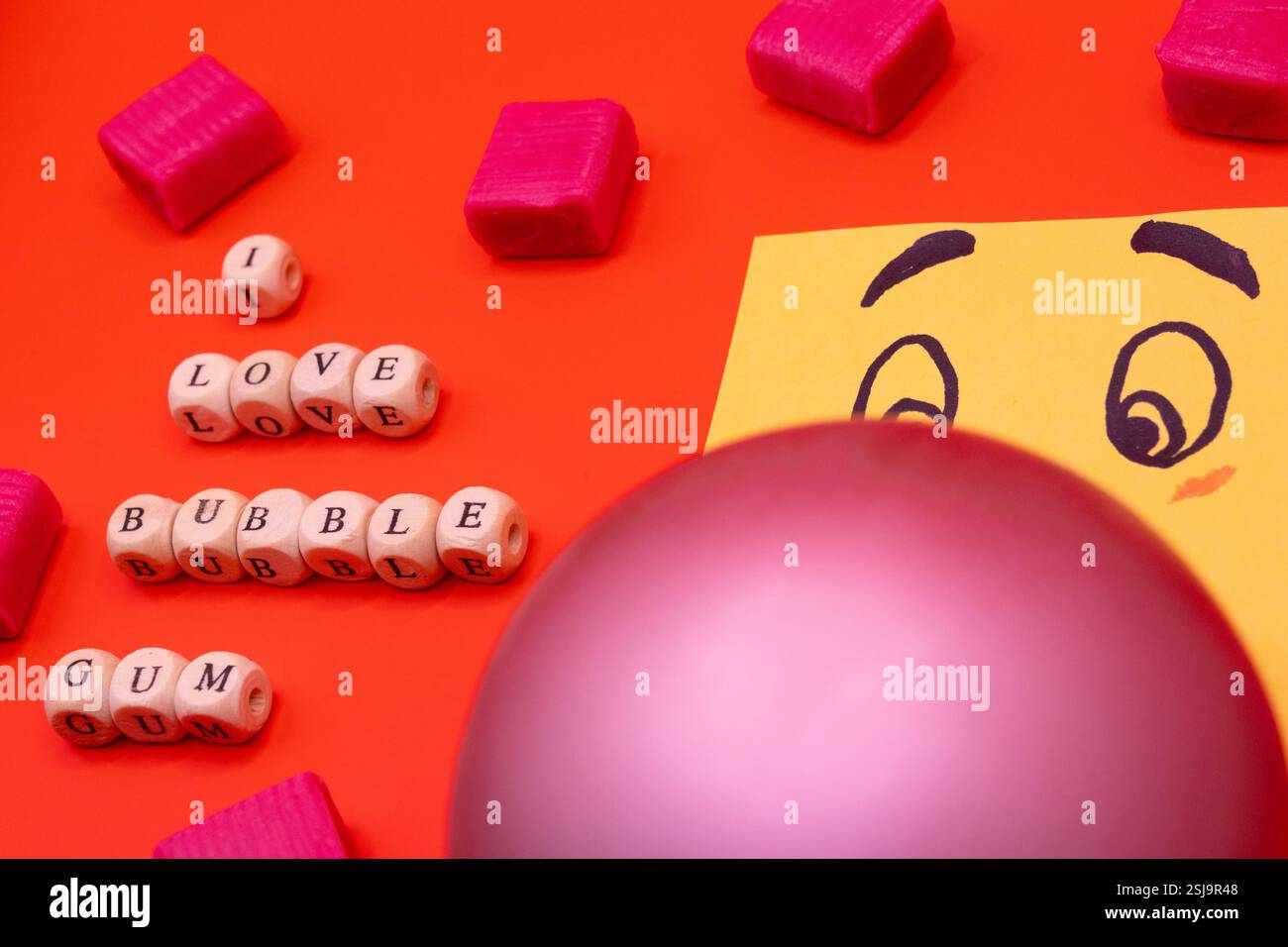 A concept of an emoticon note, blowing a bubble of bubble gum on a red ...