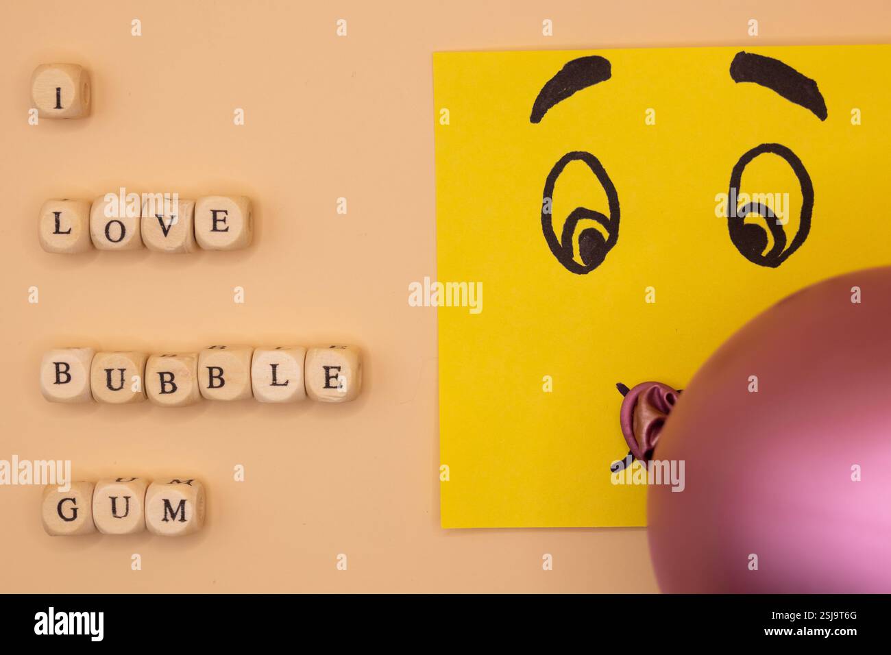 A concept of an emoticon notepad, blowing a bubble of bubble gum on a ...