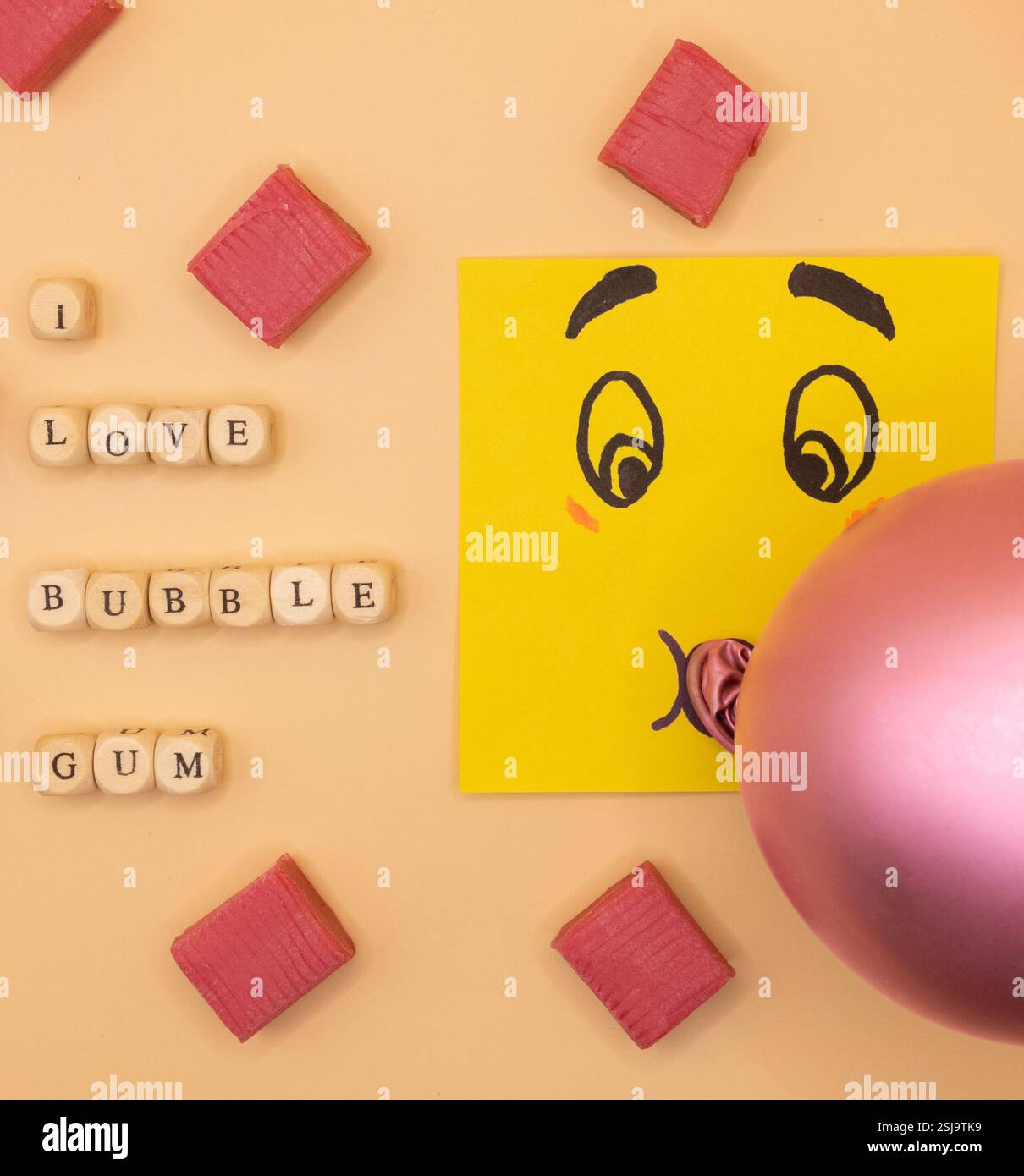 A concept of an emoticon notepad, blowing a bubble of bubble gum on a ...