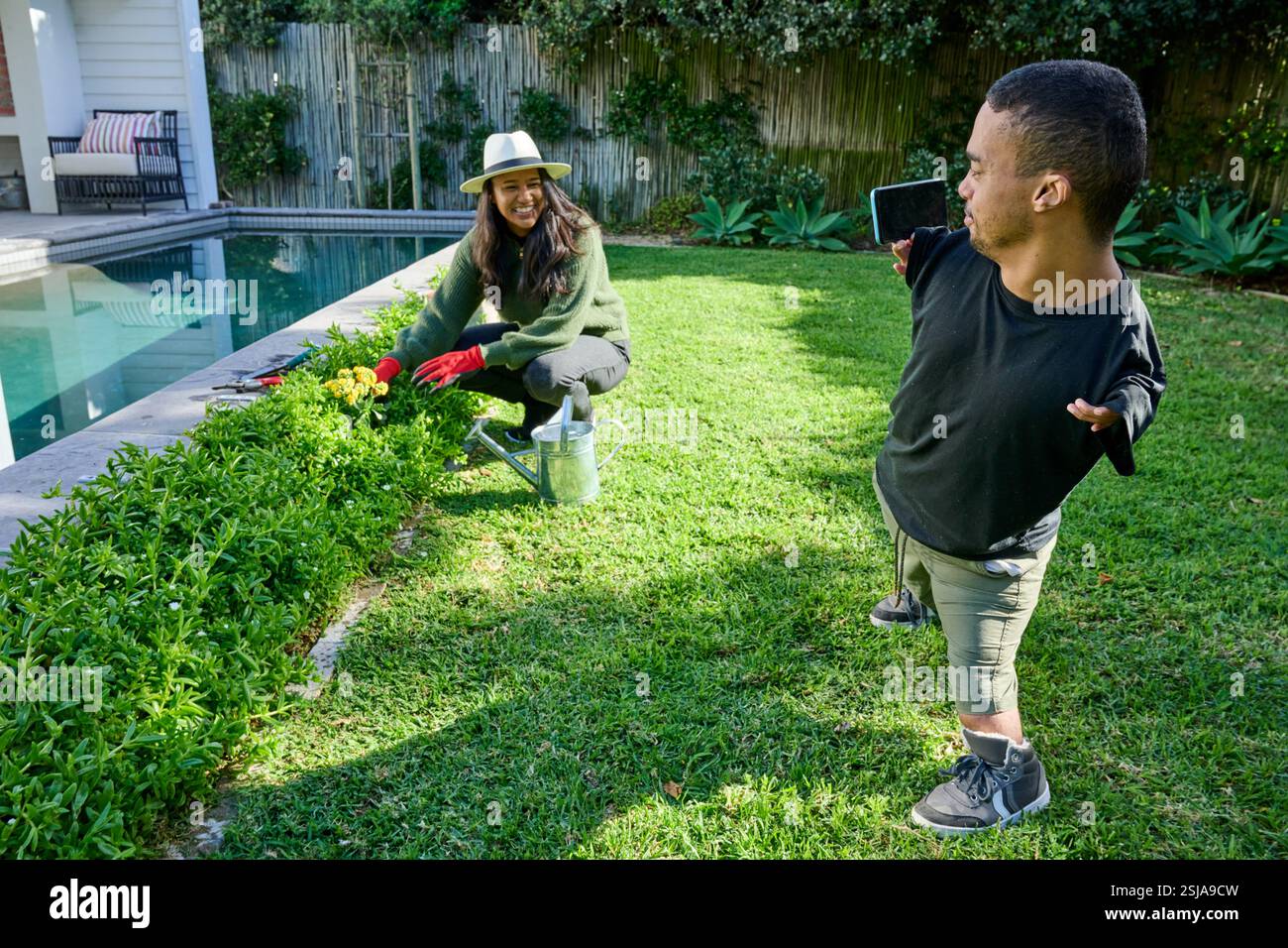 Man with phocomelia photographing woman gardening Stock Photo - Alamy