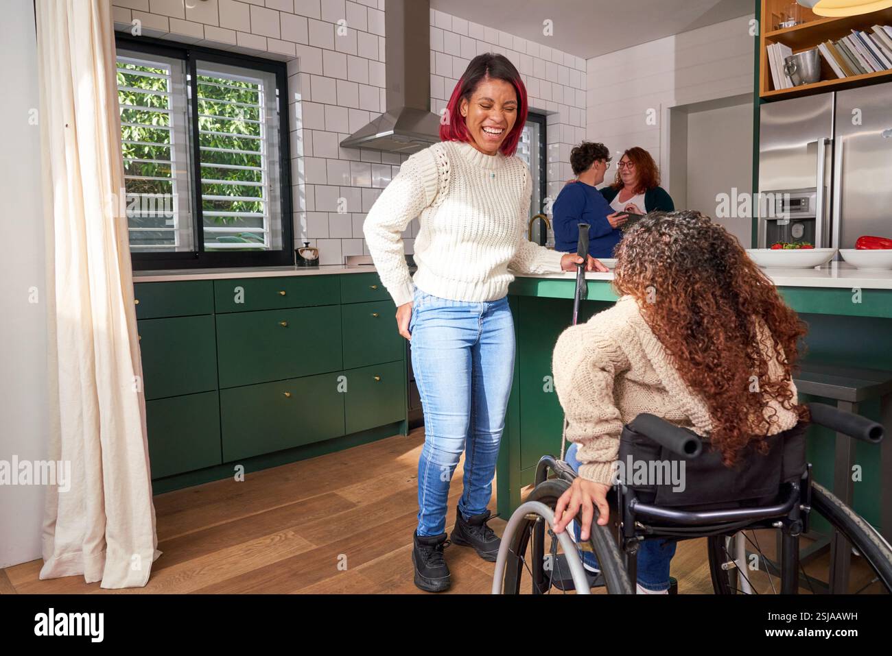 Smiling friends with different disabilities talking in kitchen Stock ...