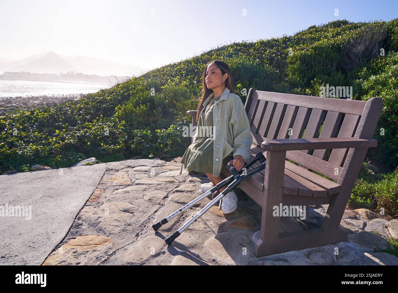 Disabled woman on bench in landscape Stock Photo - Alamy