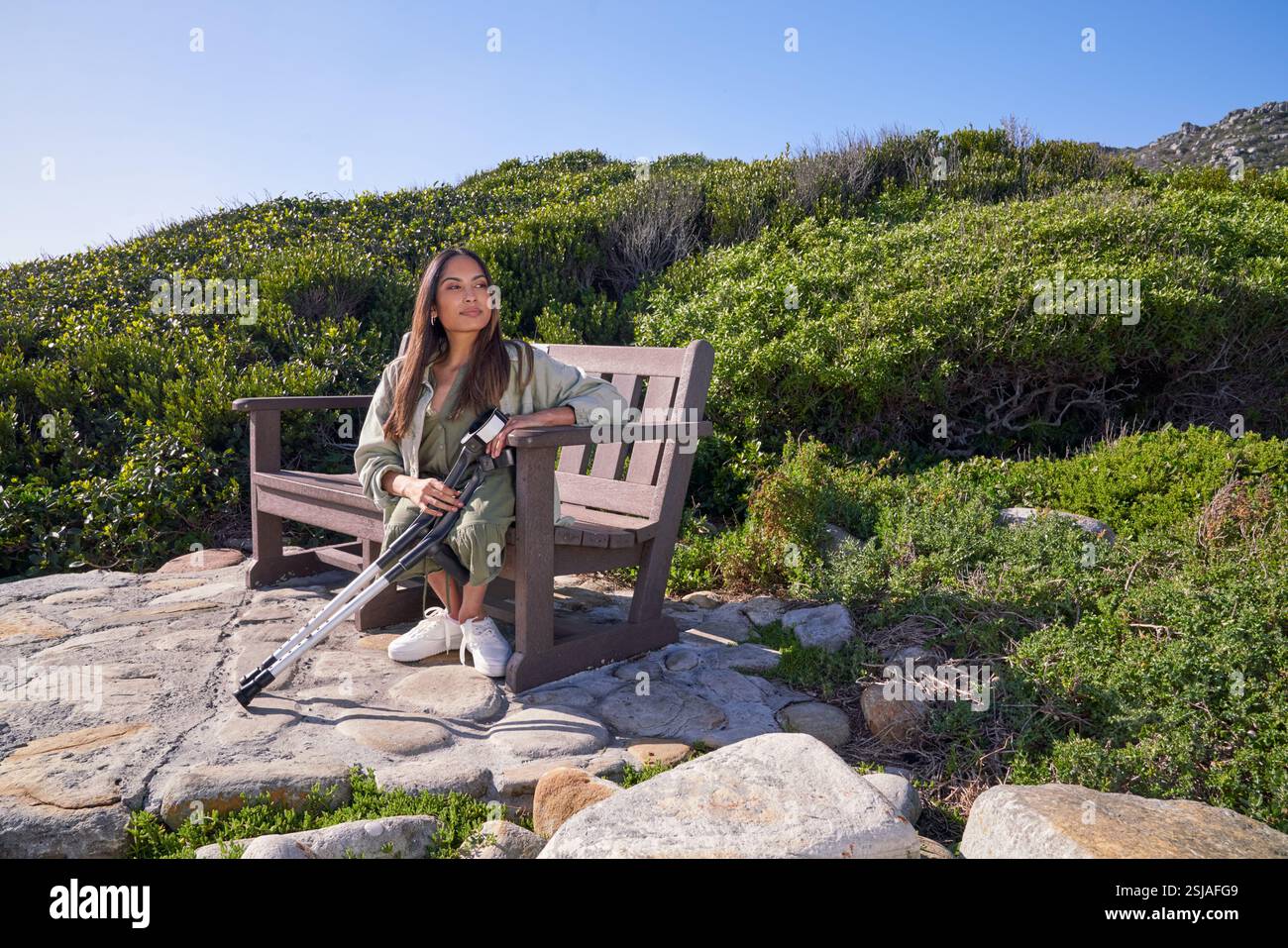 Disabled woman on bench in landscape Stock Photo - Alamy