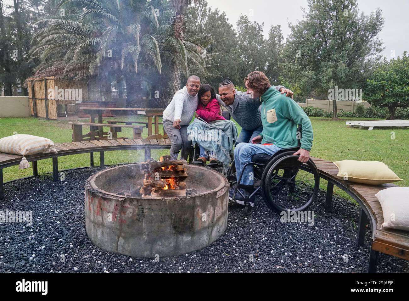 Disabled friends around fire pit Stock Photo - Alamy