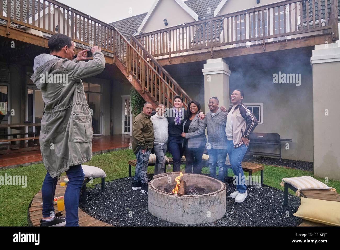 Friends around fire pit Stock Photo - Alamy