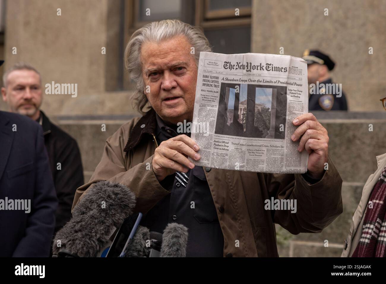 Steve Bannon shows a front page of the New York Times while speaking to ...