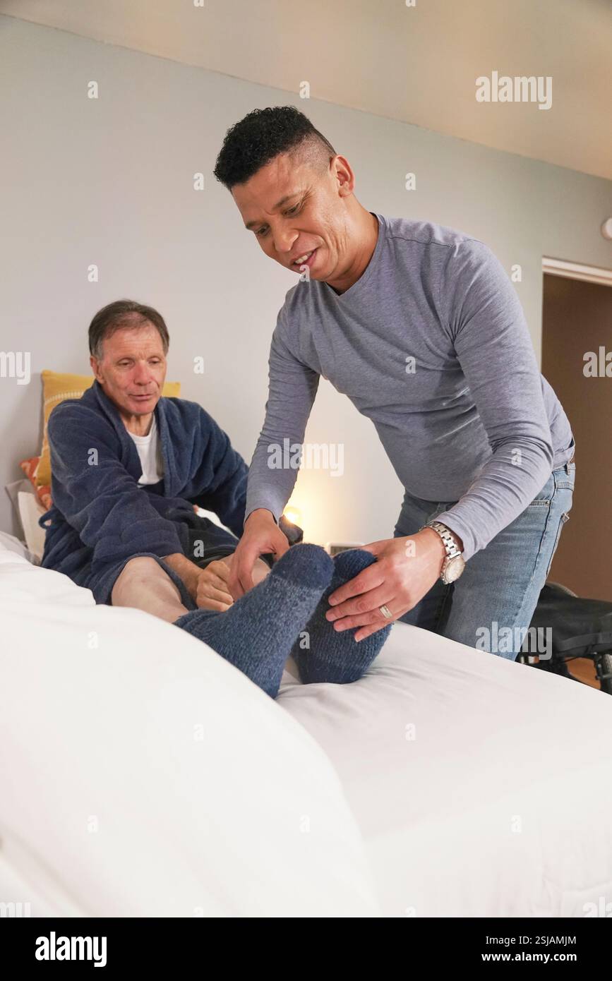 Therapist massaging disabled mans feet Stock Photo - Alamy