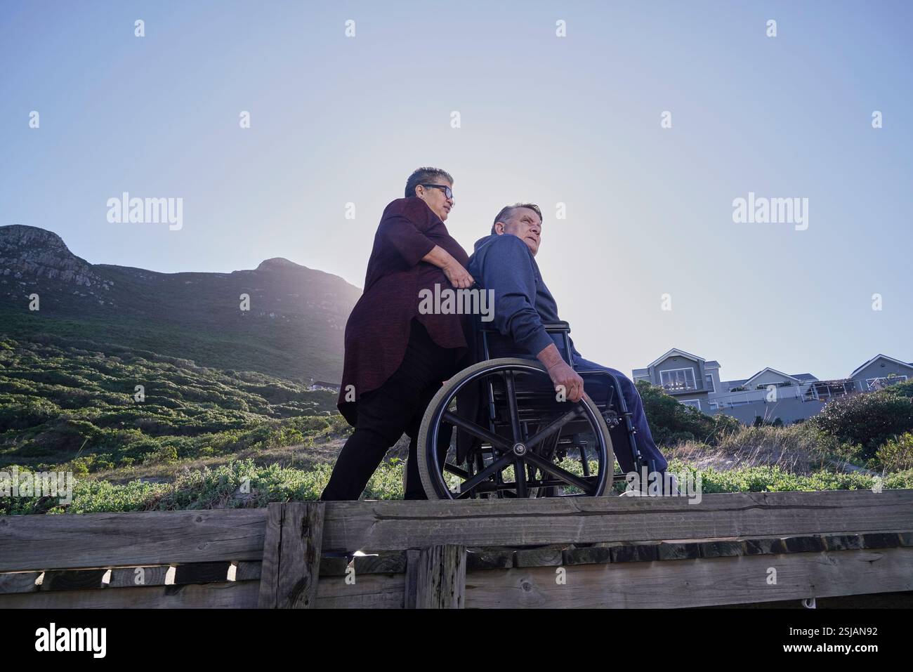 Woman pushing man in wheelchair outdoors Stock Photo - Alamy