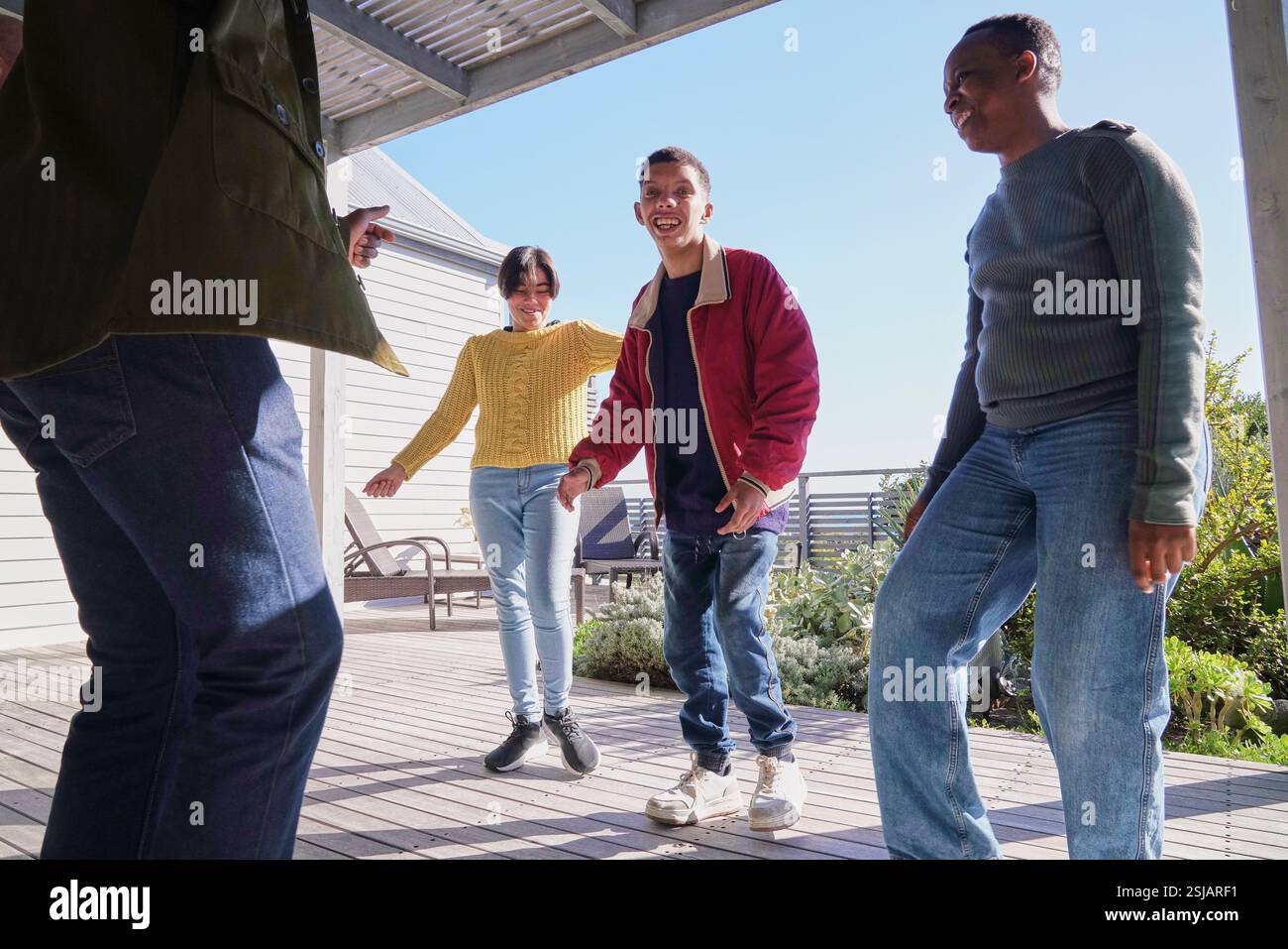 Smiling friends dancing on patio Stock Photo - Alamy