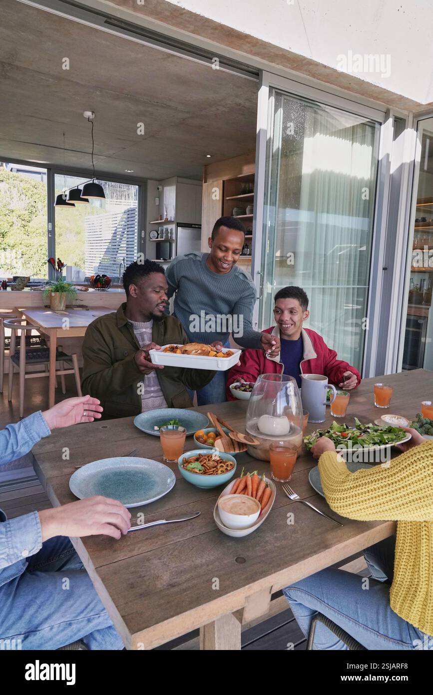 Smiling friends eating on patio Stock Photo - Alamy