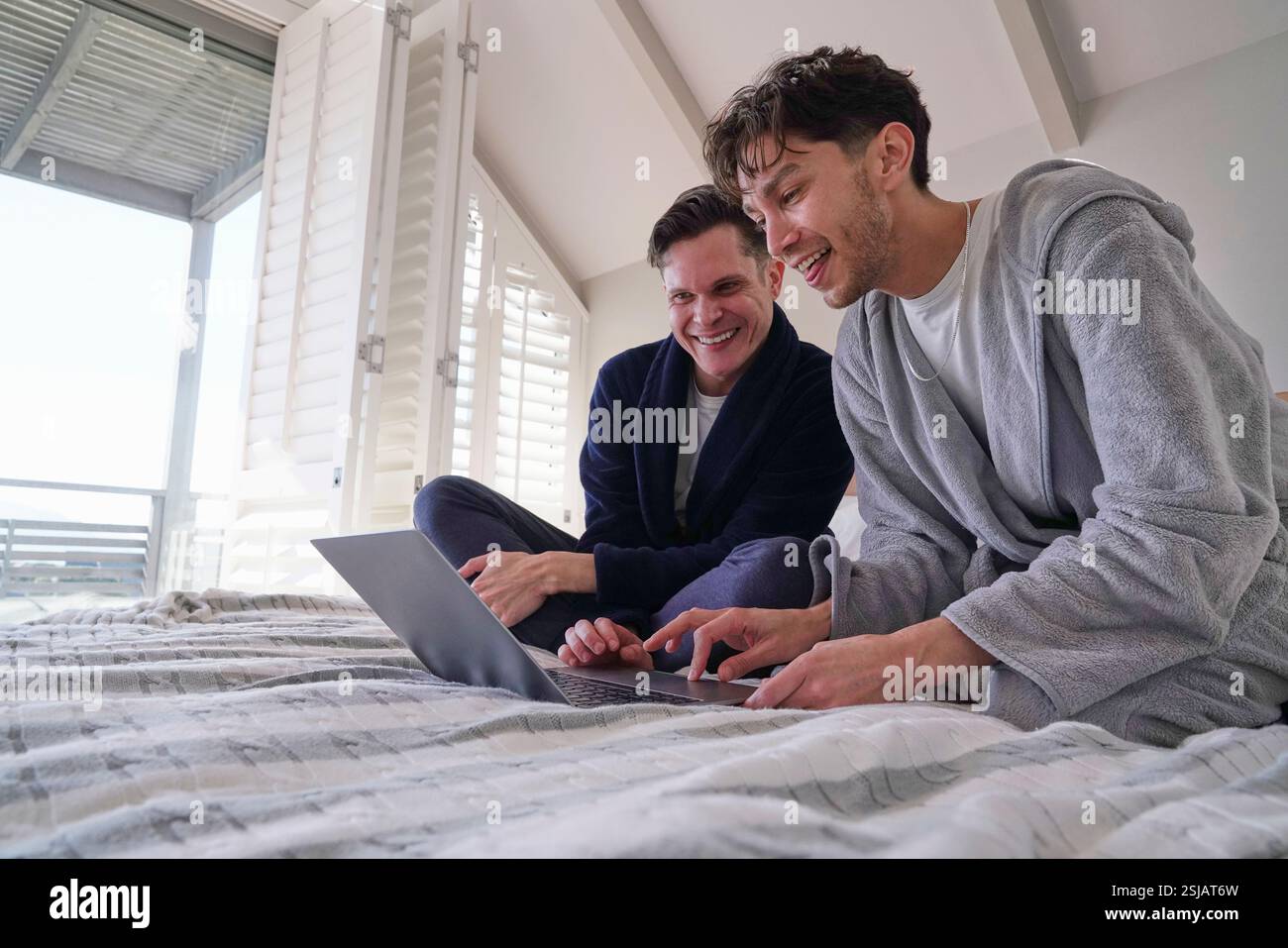 Happy man sitting on bed hi-res stock photography and images - Alamy