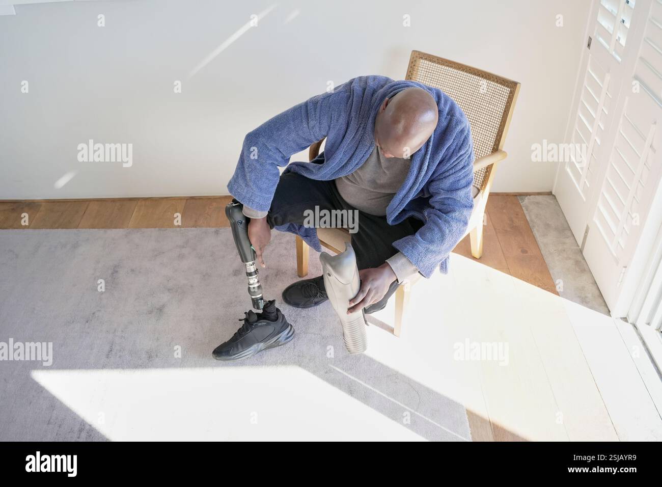 Man with leg prosthesis sitting on chair Stock Photo - Alamy