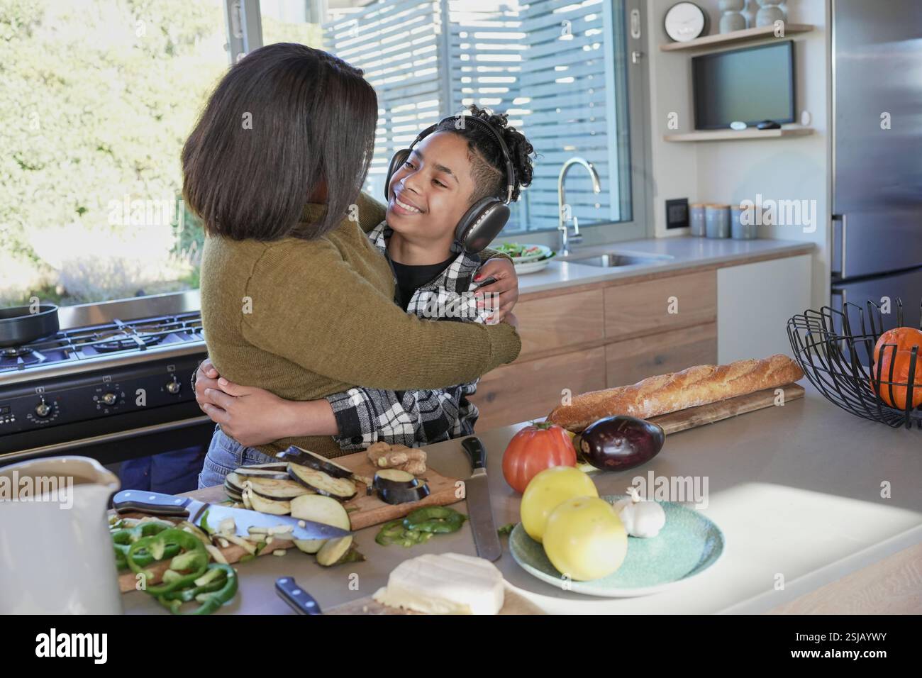 Sister and brother embracing in kitchen Stock Photo - Alamy
