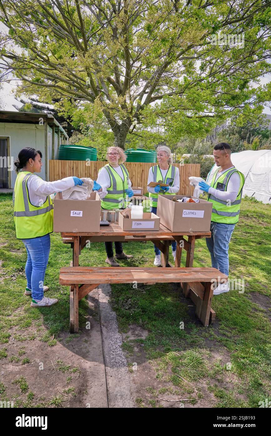 Group of volunteers packaging donation boxes at table outdoors Stock ...