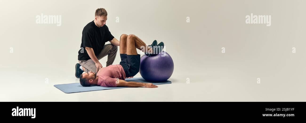 Trainer guiding man in bridge exercise with stability ball, ensuring ...