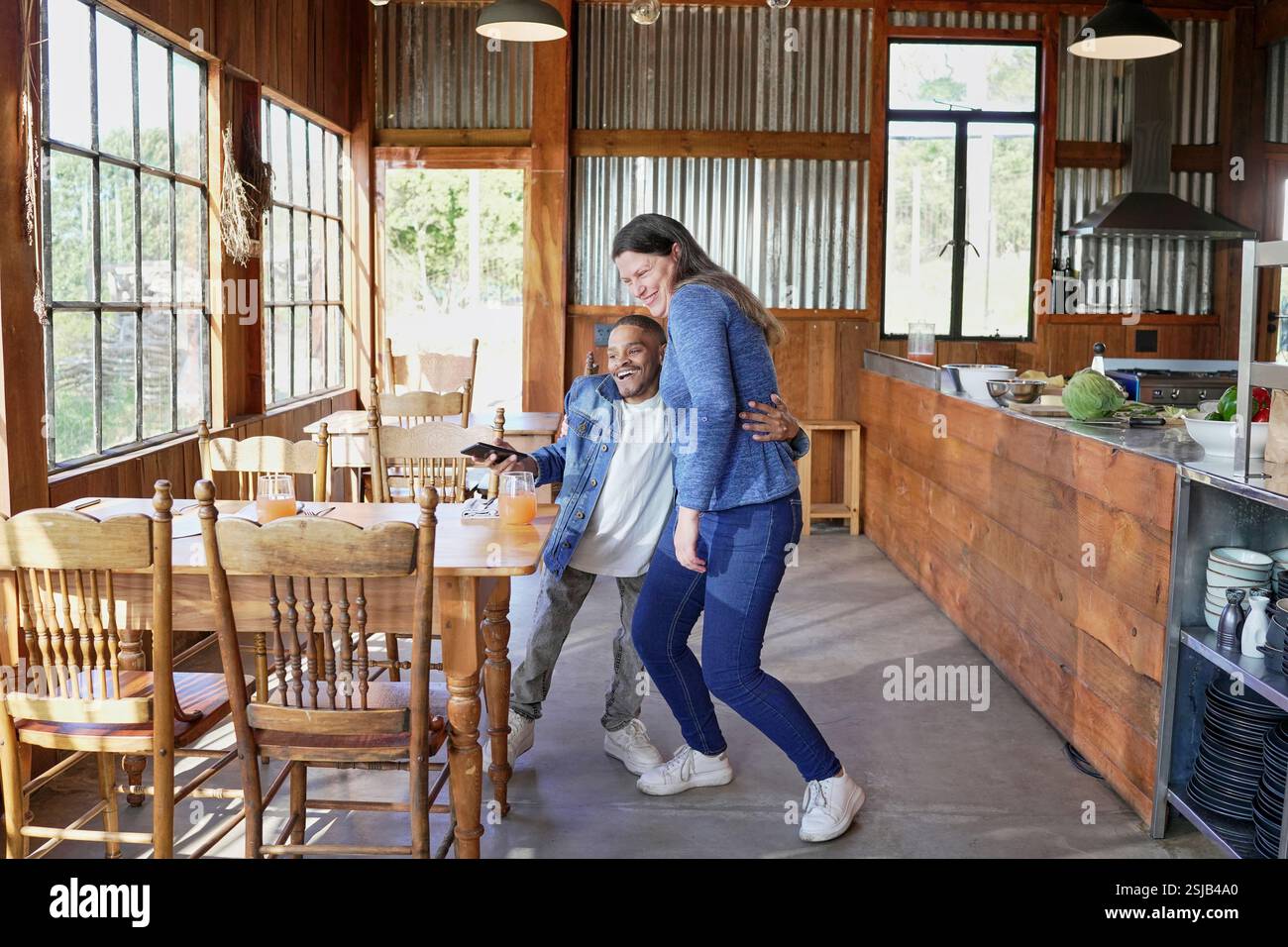 Two employees standing and embracing in restaurant Stock Photo - Alamy